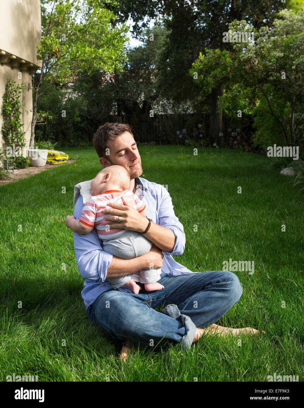 Caucasian father holding baby in backyard Stock Photo - Alamy