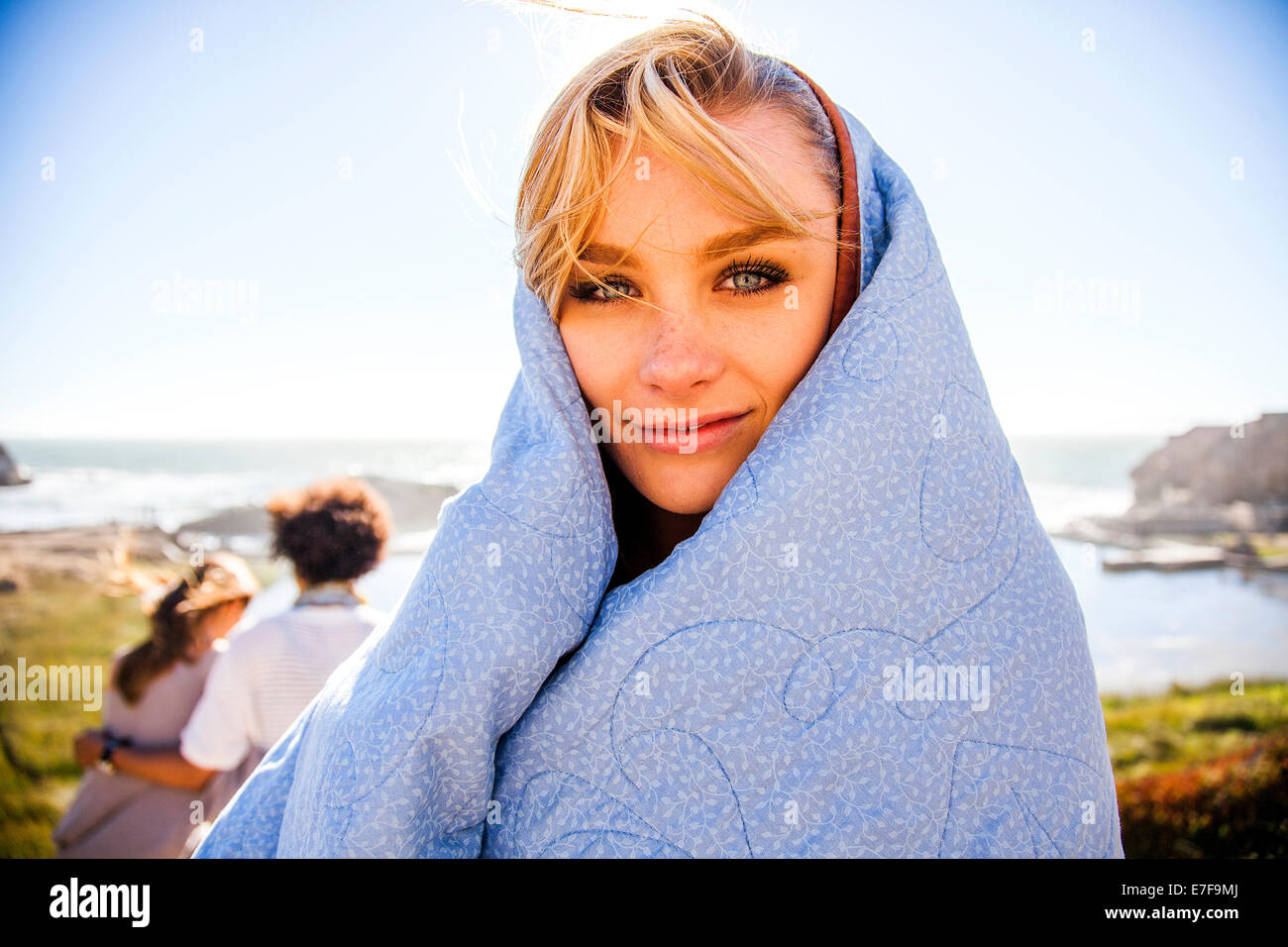 Woman wrapped in blanket on rural hillside Stock Photo - Alamy