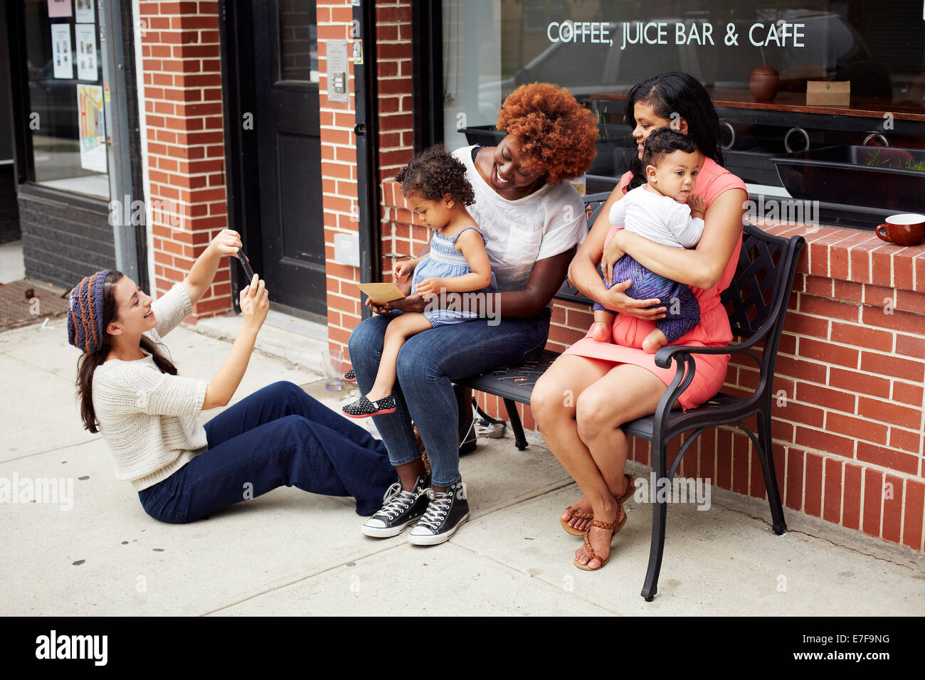 Friends taking cell phone pictures together on city street Stock Photo ...