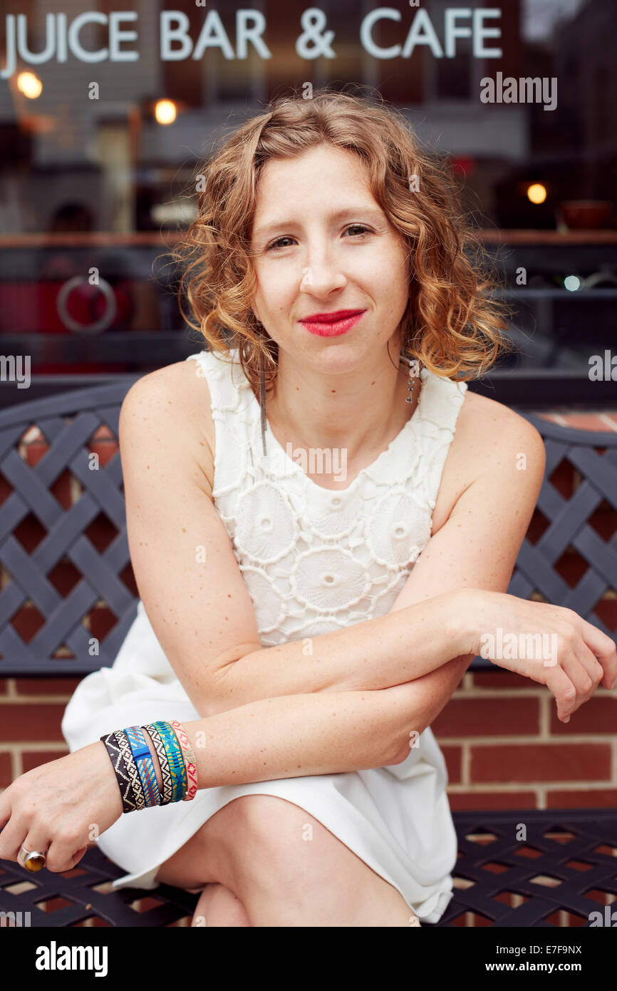 Caucasian woman sitting outside coffee shop on city street Stock Photo ...