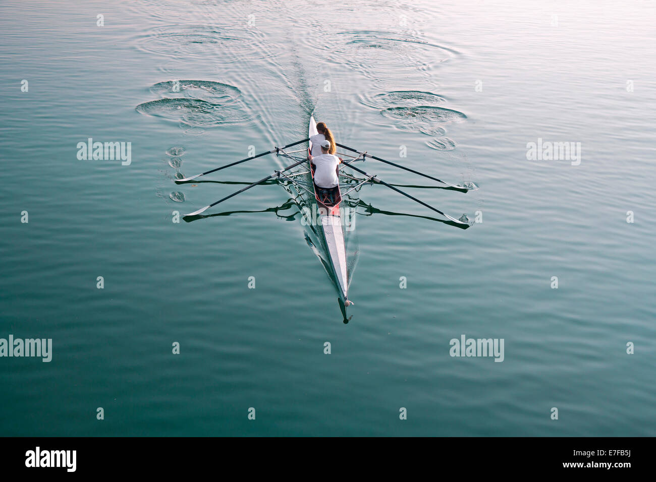 Man and woman in a boat, rowing on the tranquil lake Stock Photo - Alamy