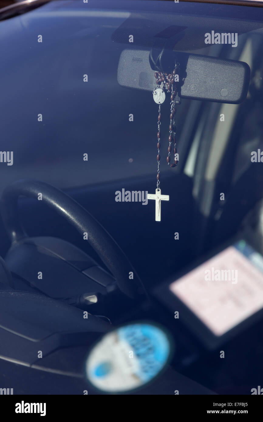 Crucifix hanging from rear view mirror in a car Stock Photo - Alamy
