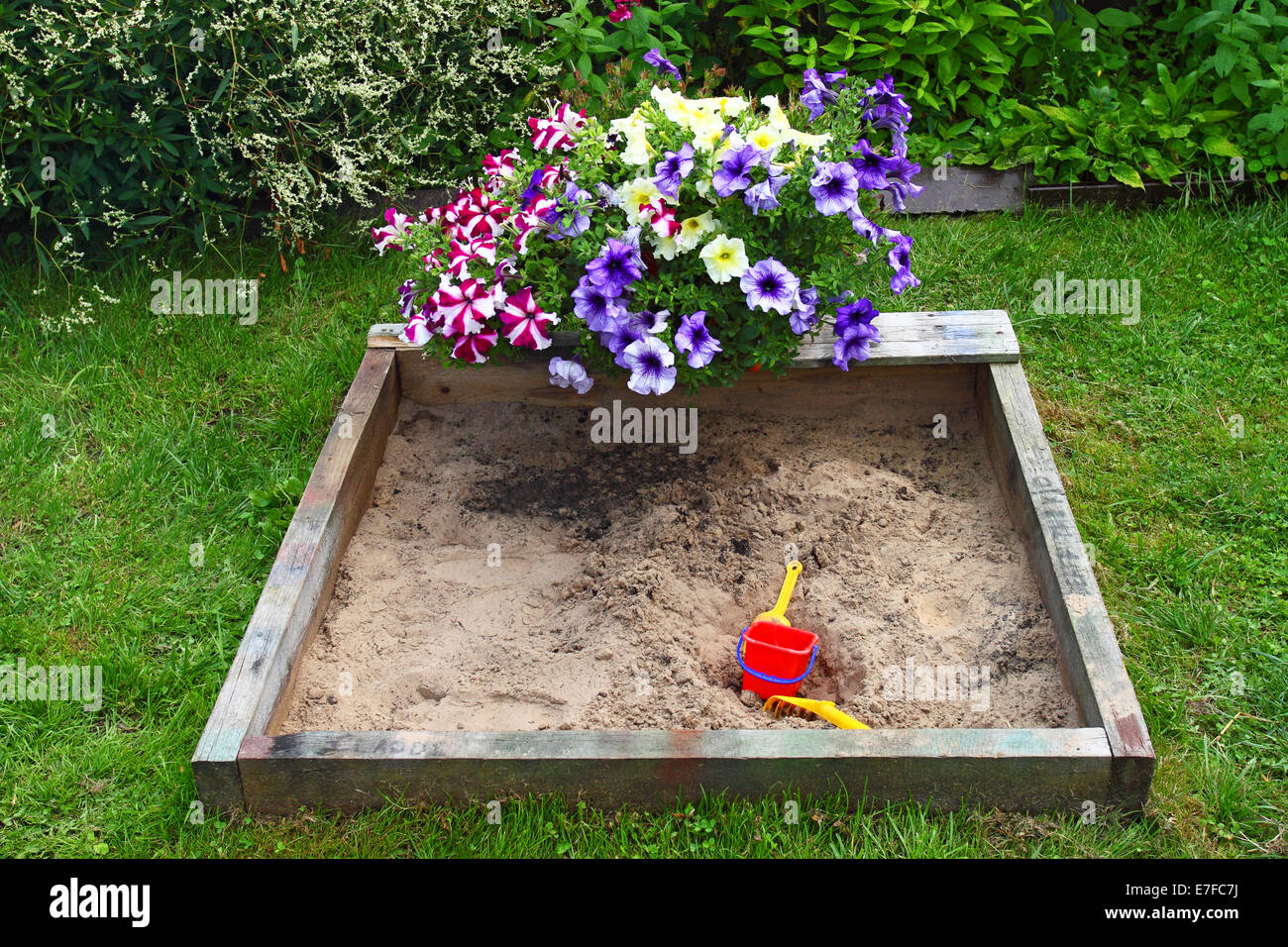 Sandbox in garden with flowers above it Stock Photo - Alamy