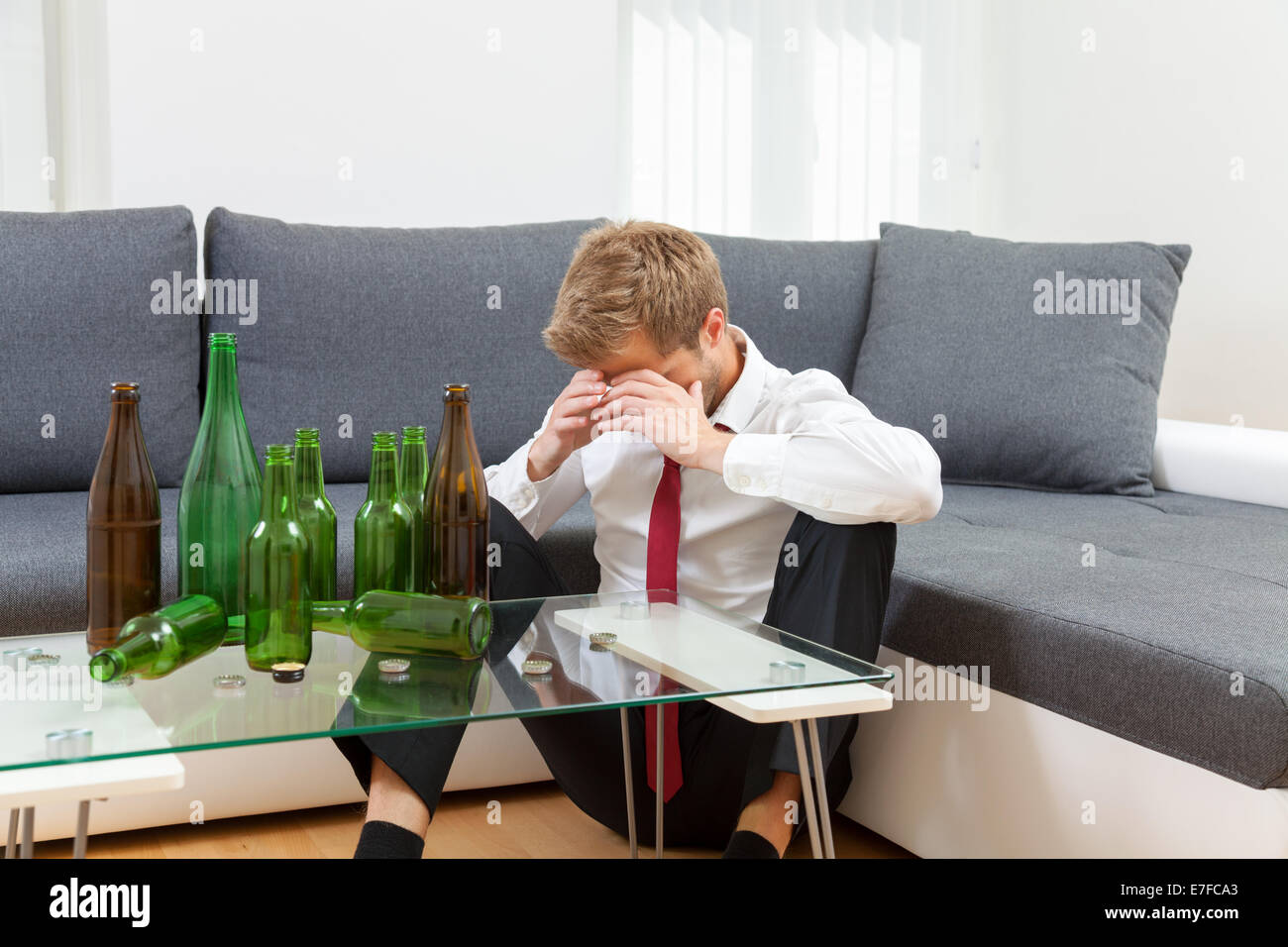 Depressed businessman drunk at home with empty bottles on table Stock ...