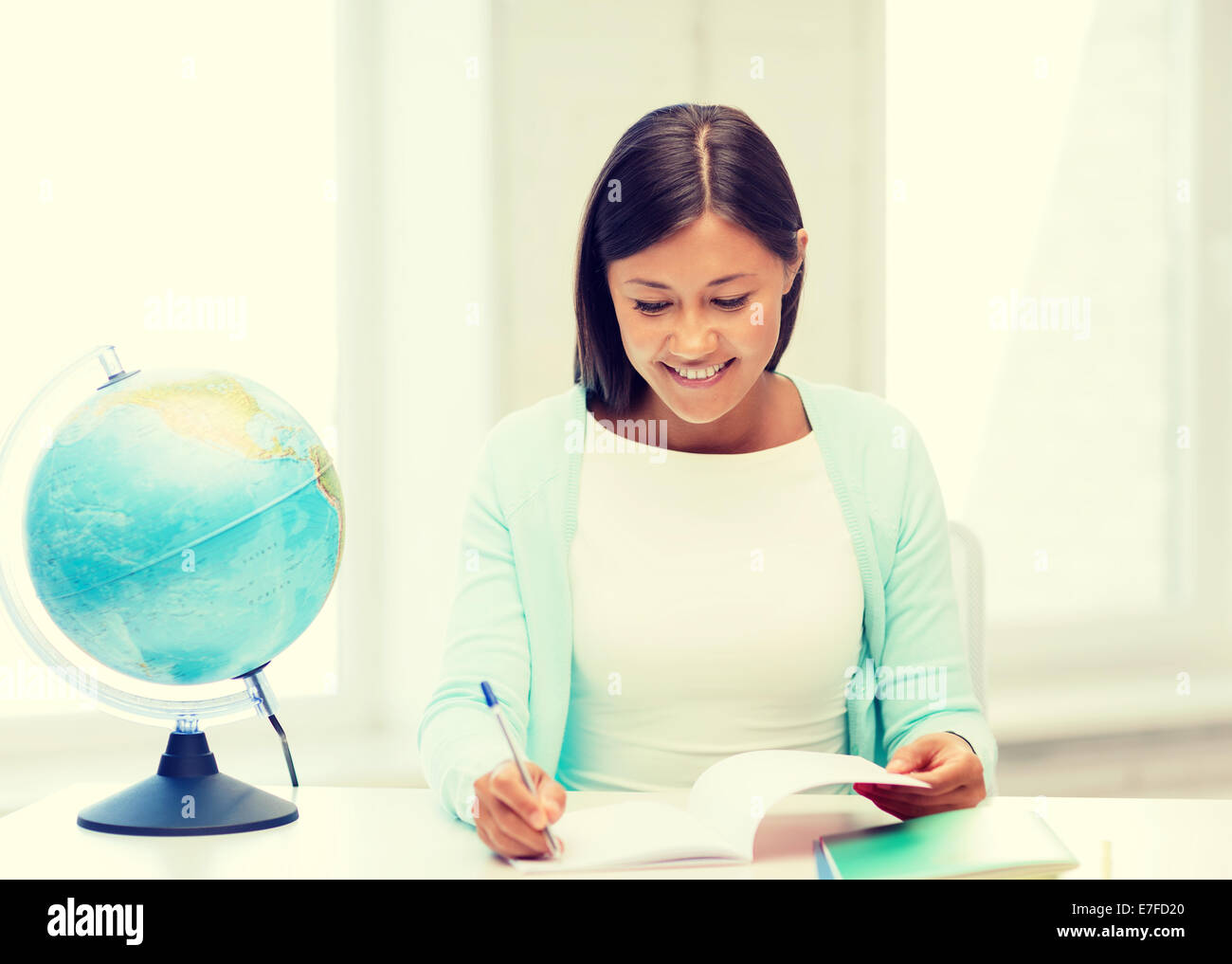 teacher with globe and notepad at school Stock Photo - Alamy