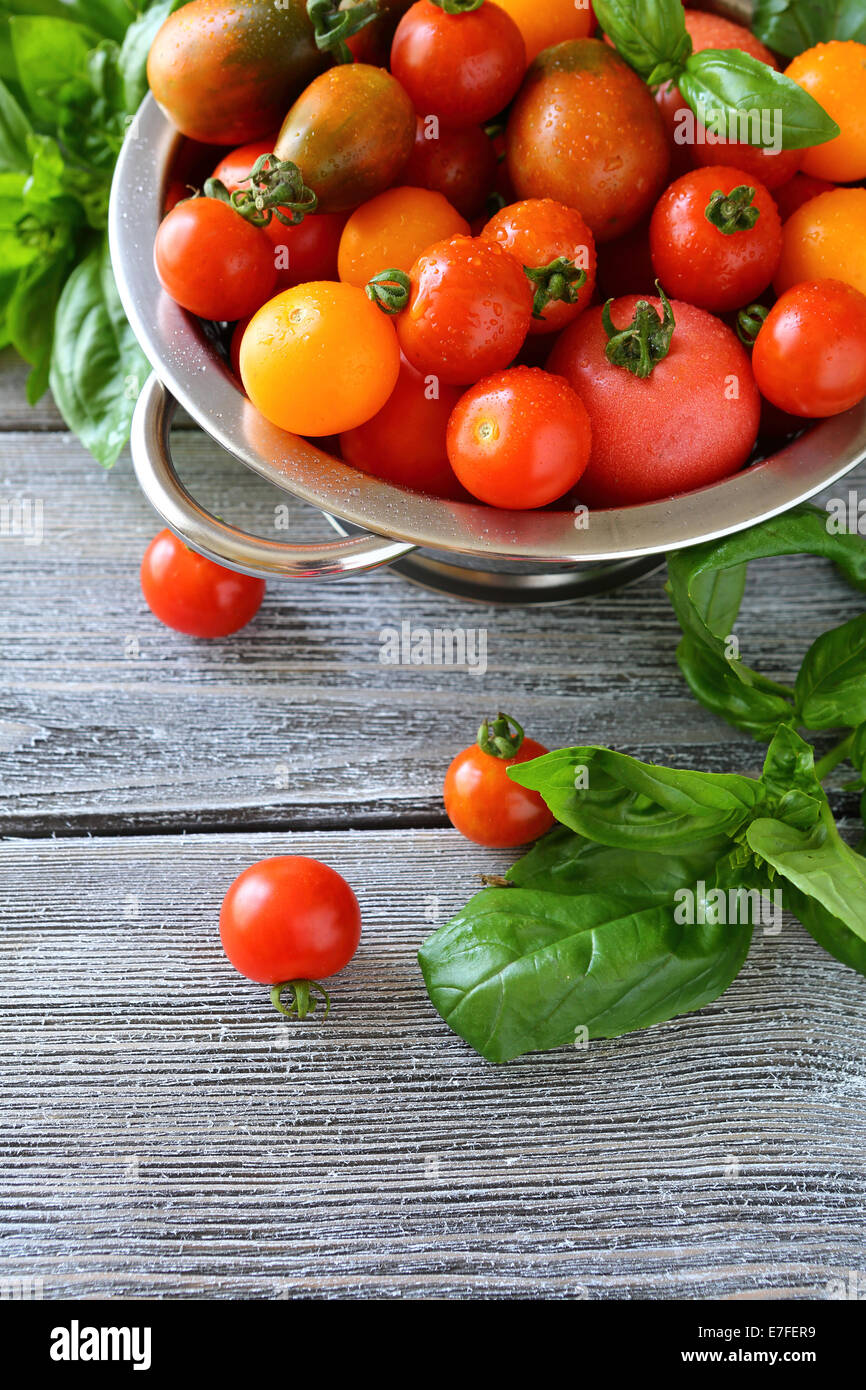 Cherry tomatoes and basil top view, in the iron colander Stock Photo ...