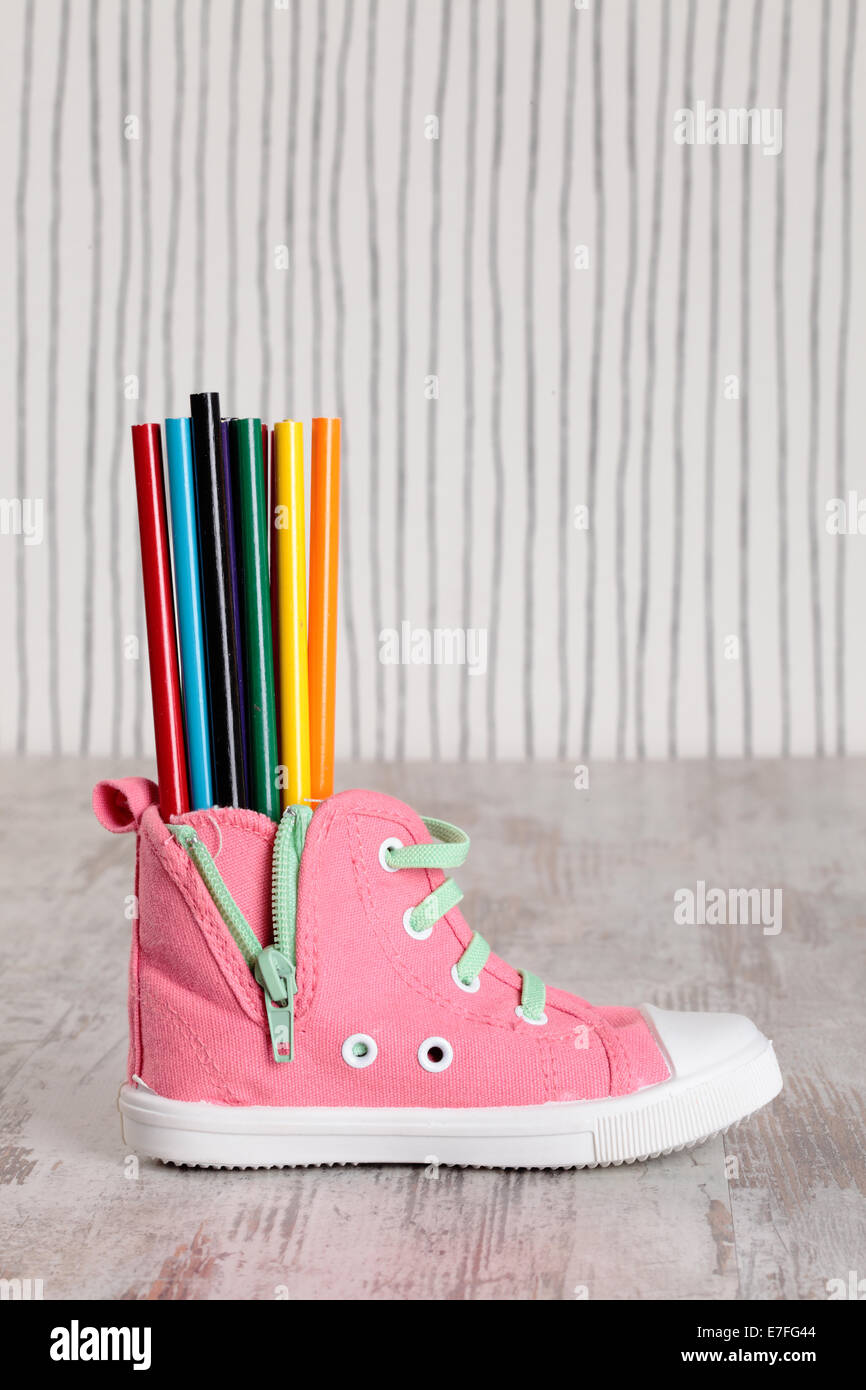 child shoe with colored pencils on an striped background Stock Photo ...