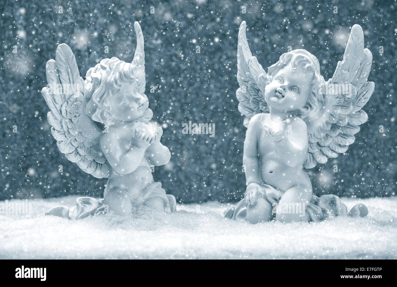little guardian angels in snow on shiny lights background. christmas ...