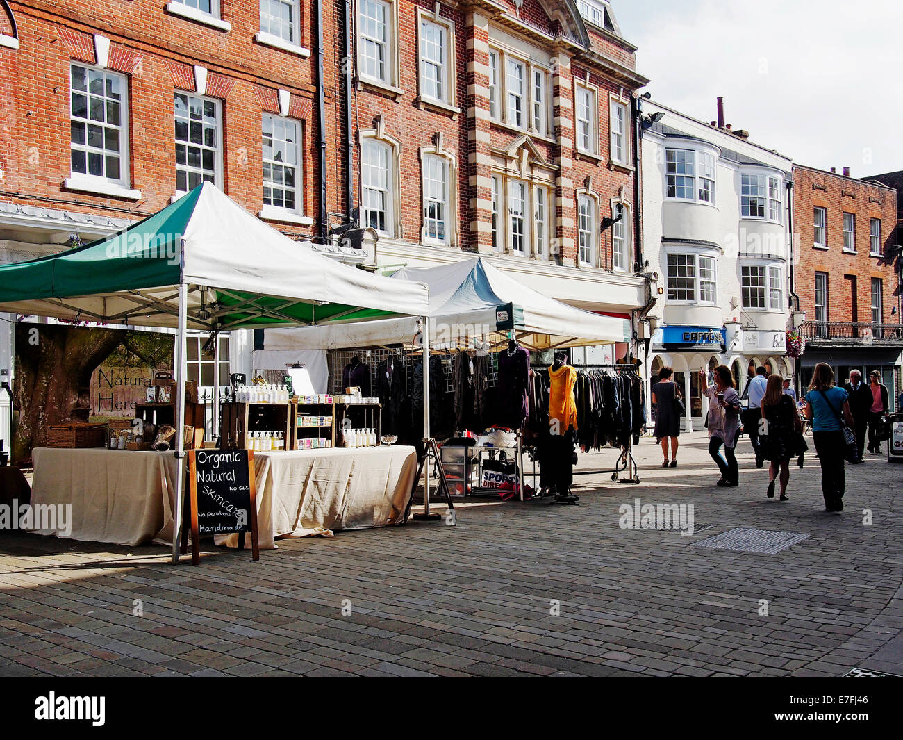 Street market stalls selling fashion and skin care products with shops ...