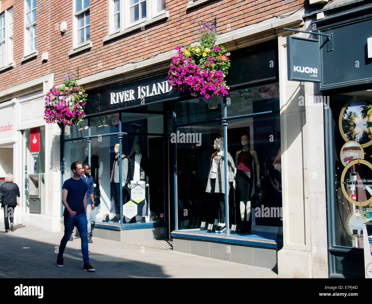 Young man glances towards the window display of a River Island shop in ...