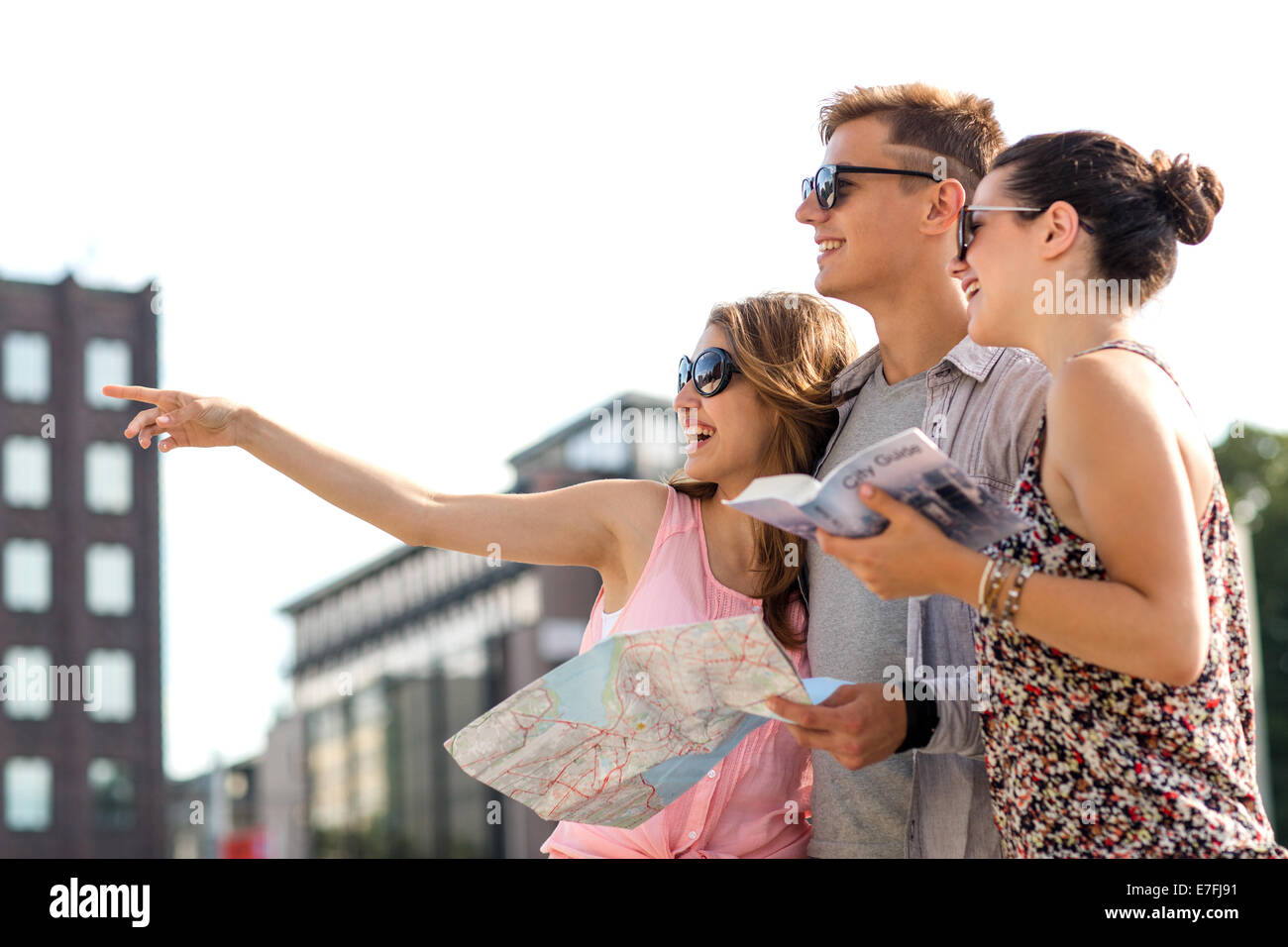 smiling friends with map and city guide outdoors Stock Photo - Alamy