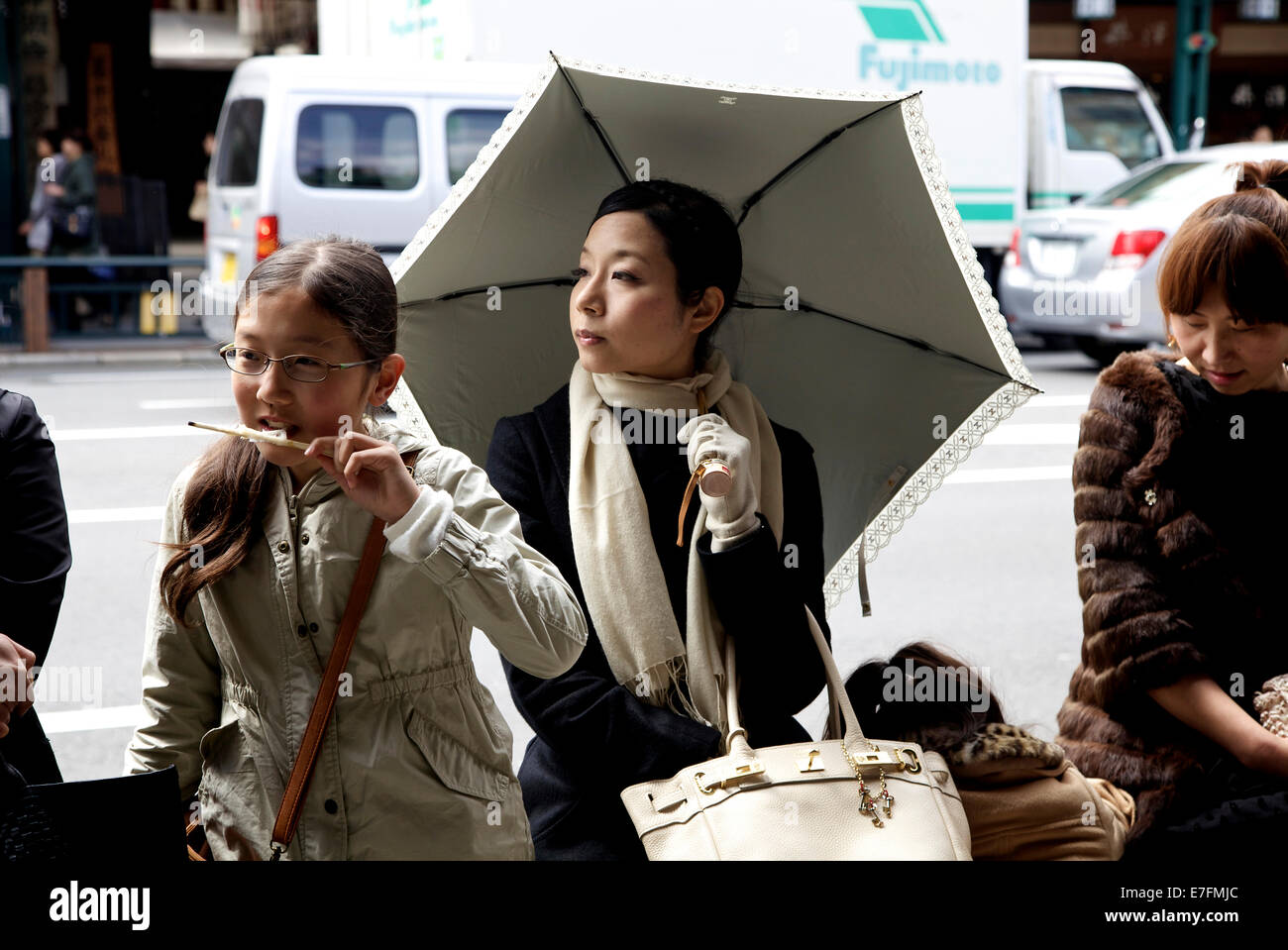 Trendy young Japanese woman waiting for the bus with umbrella. Kyoto ...