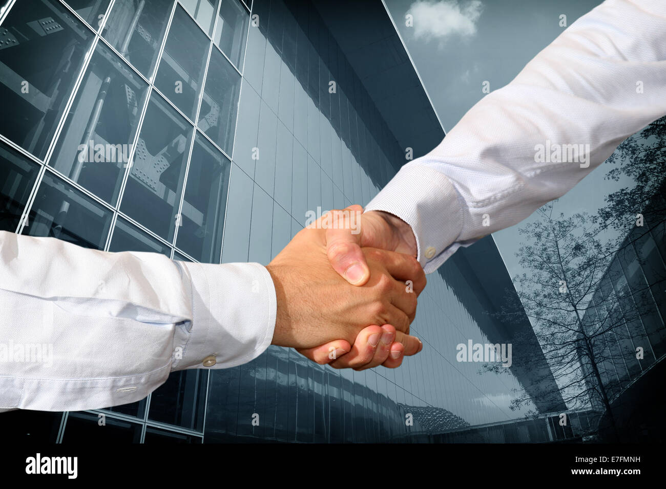 Handshake in the city, focus on handshake Stock Photo - Alamy