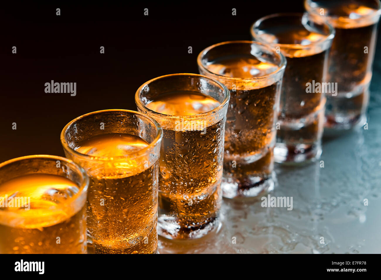 Glasses with an alcoholic drink on a damp glass table Stock Photo - Alamy