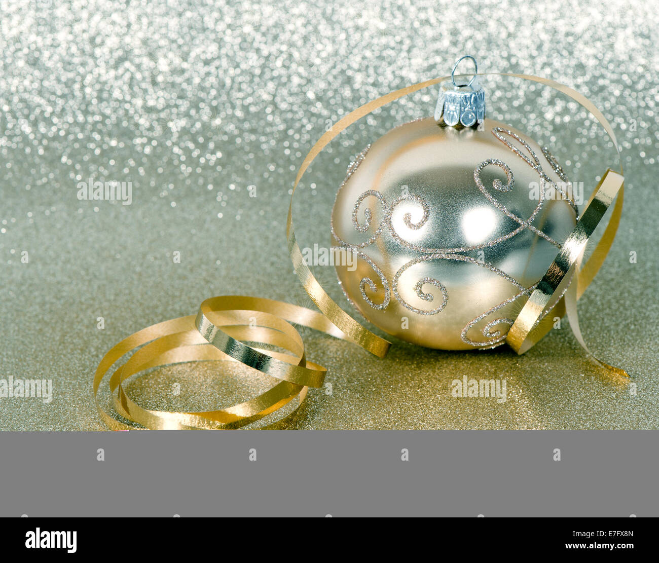 golden christmas ball with streamer on blurred shiny background with ...