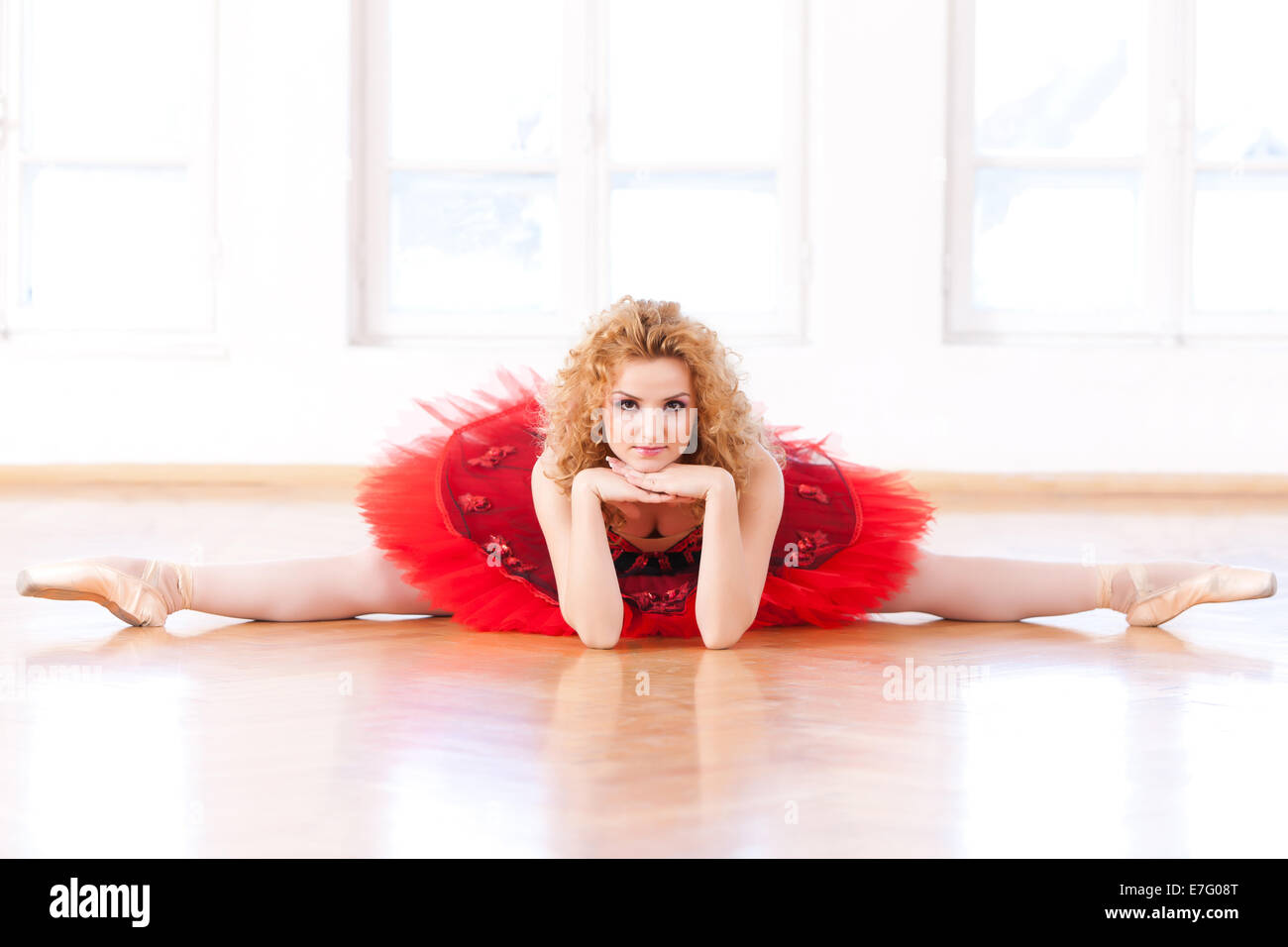Beautiful ballerina, in split position, looking at camera and smiling ...