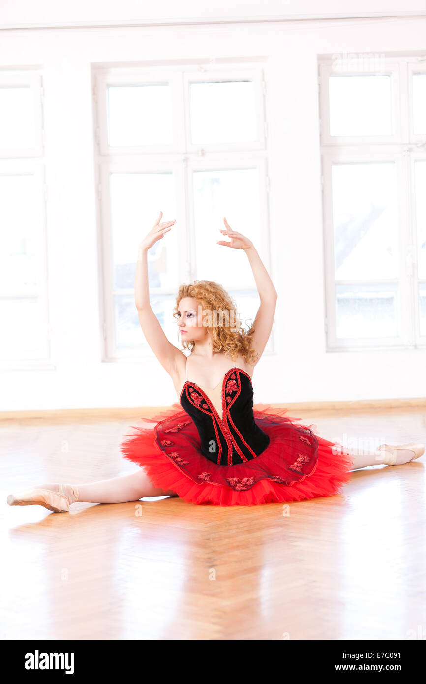 Very beautiful ballerina profile in red tutu executing a split position ...