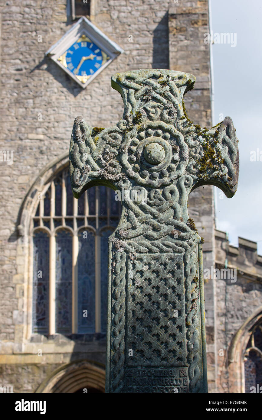 A carved stone cross in the grounds of Kendal Parish Church in Cumbria ...