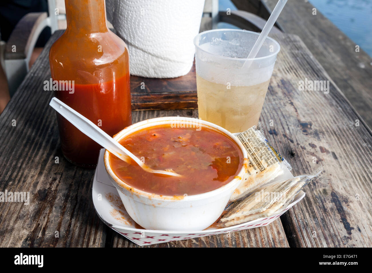 Styrofoam bowl of conch chowder a plastic spoon, bottle of hot sauce ...