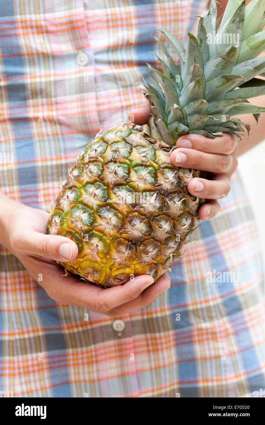 Pineapple in woman's hands Stock Photo - Alamy
