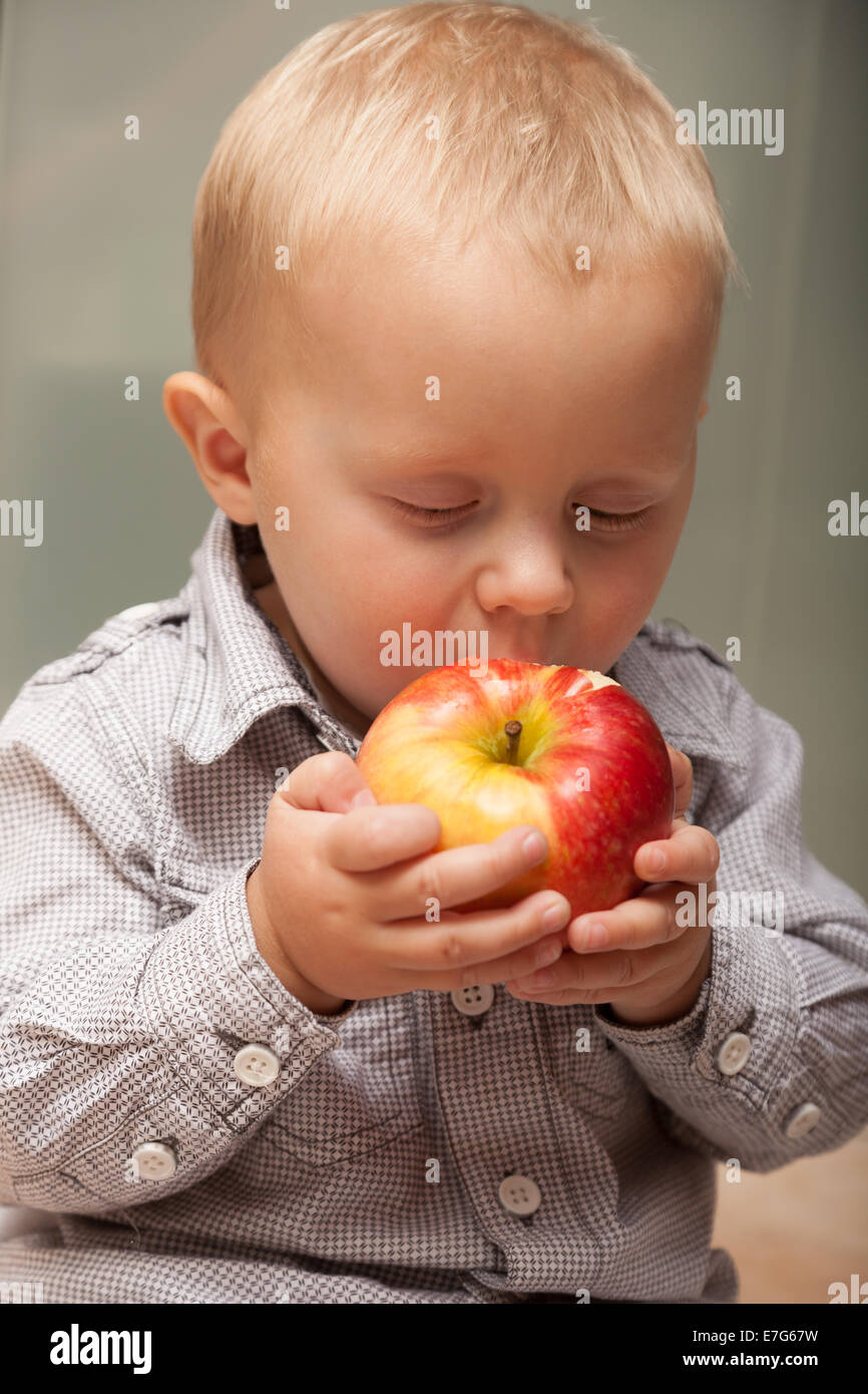 Happy childhood. Portrait of cute little boy child kid eating apple ...