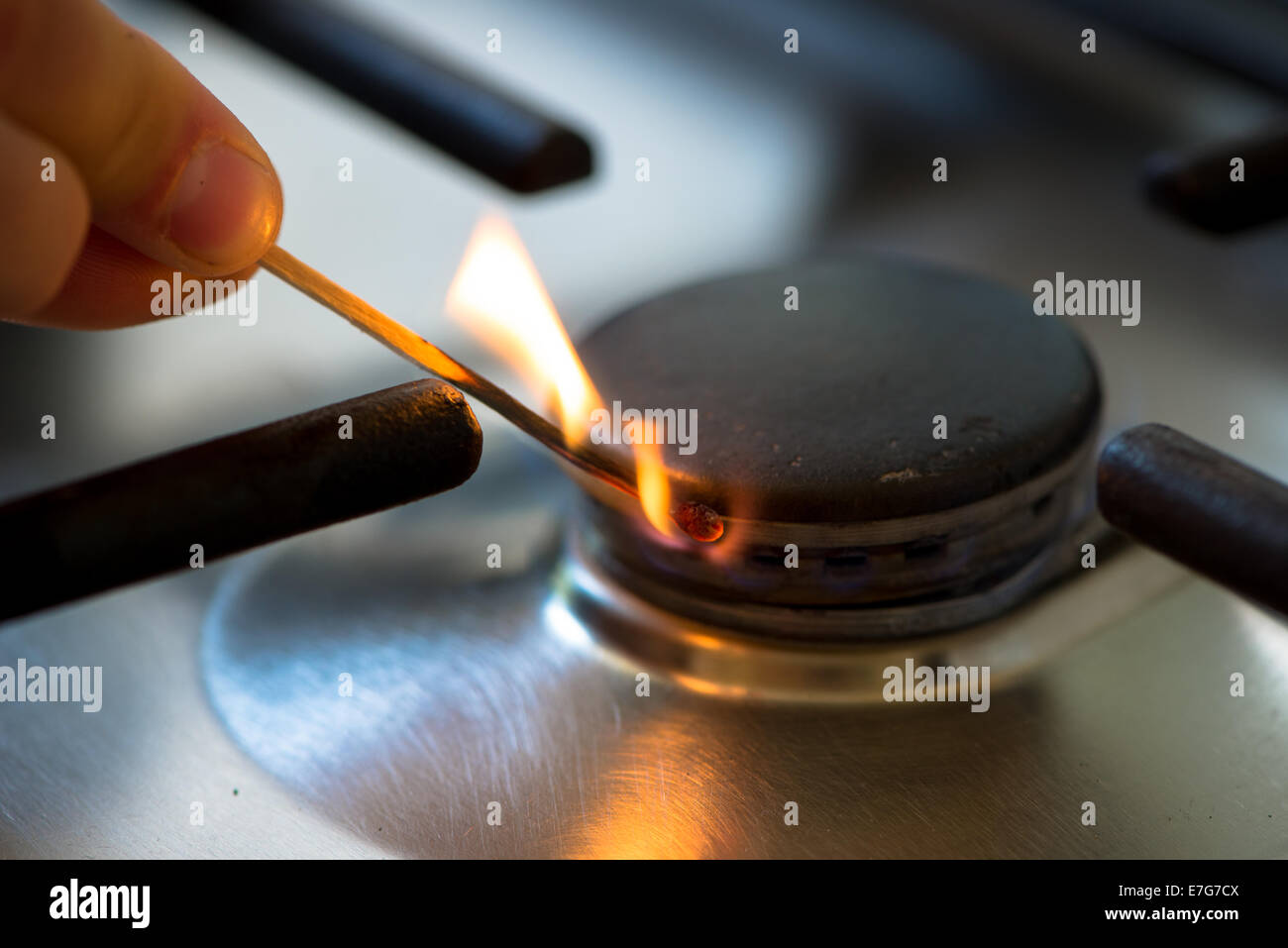 match ignites gas burner in kitchen Stock Photo - Alamy