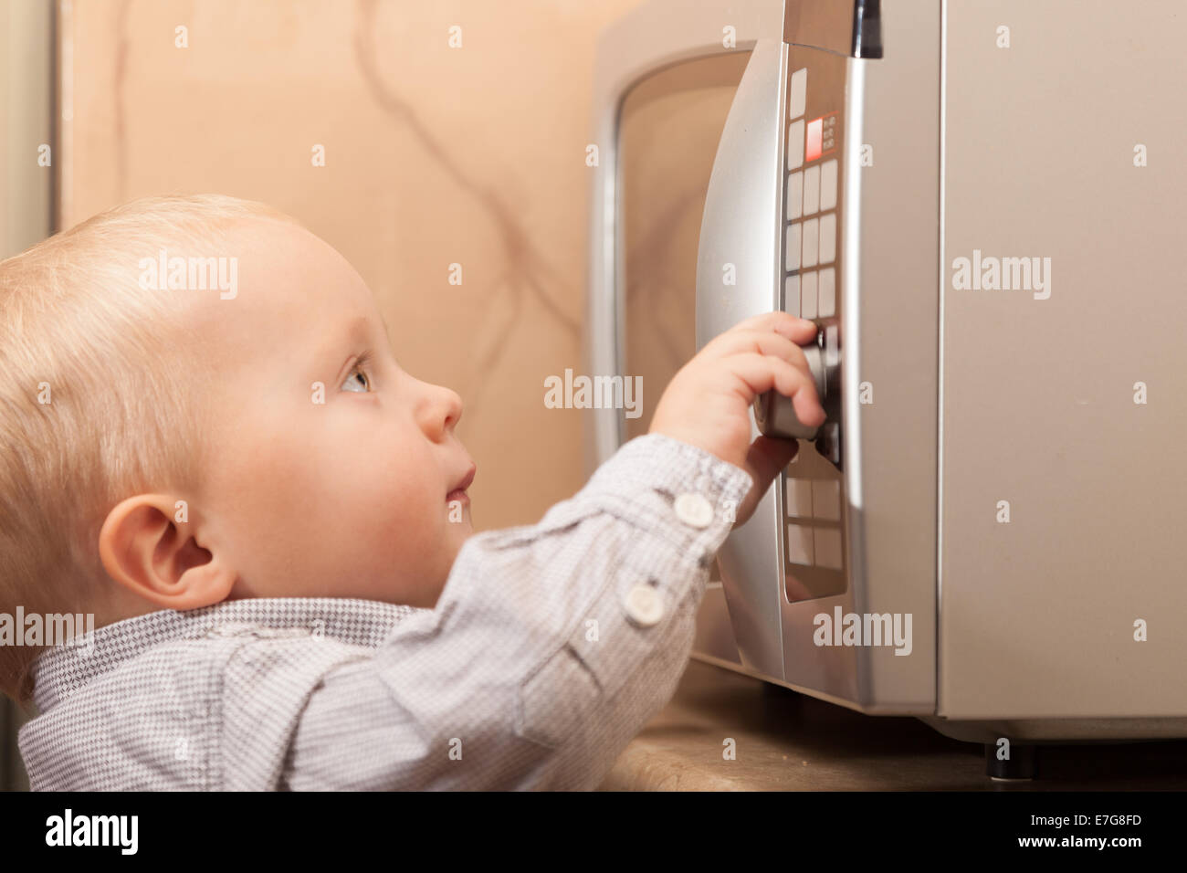 Childhood. Little boy child kid playing with timer of microwave oven ...