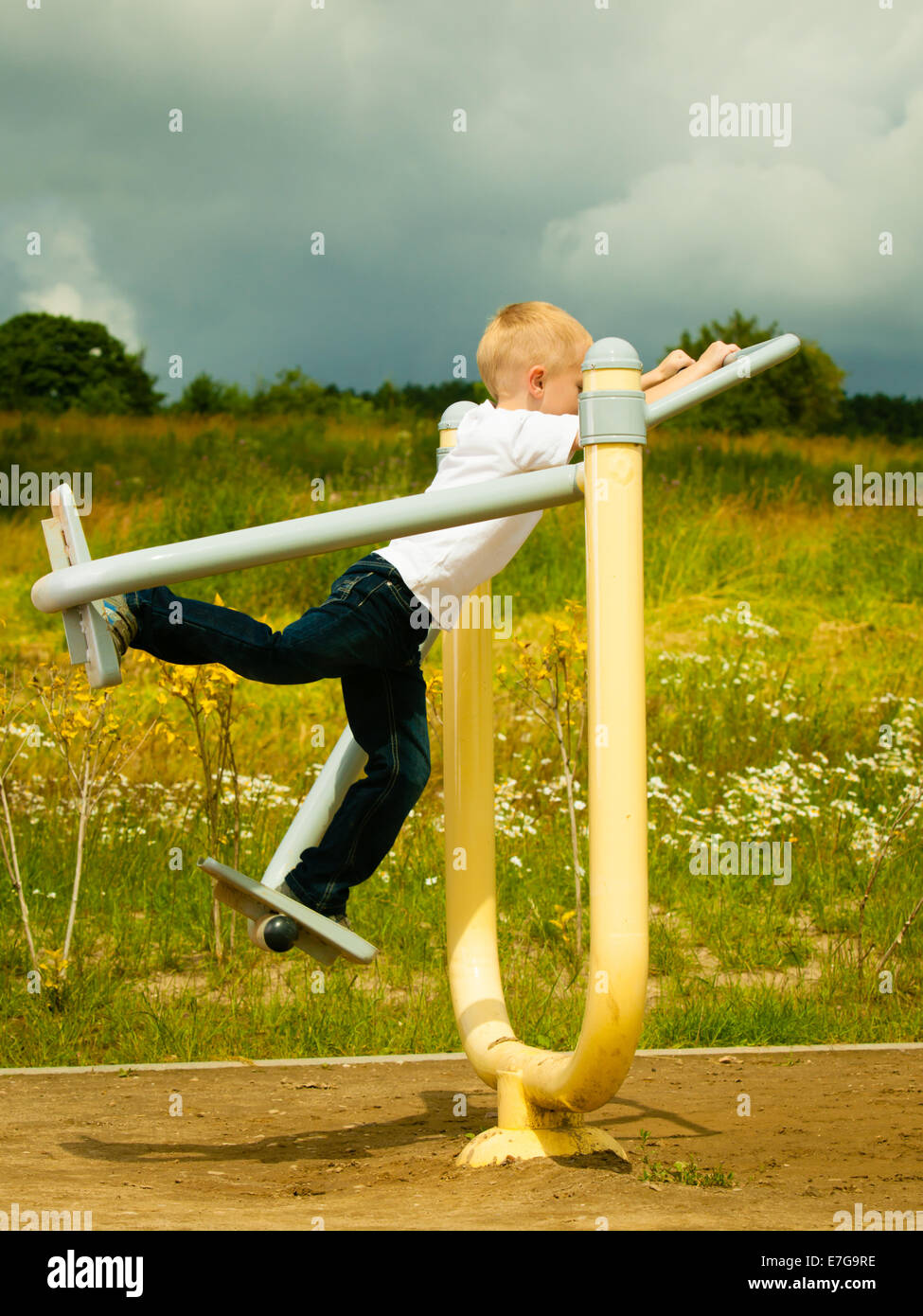 Child in playground kid in action boy playing on stretching equipment ...