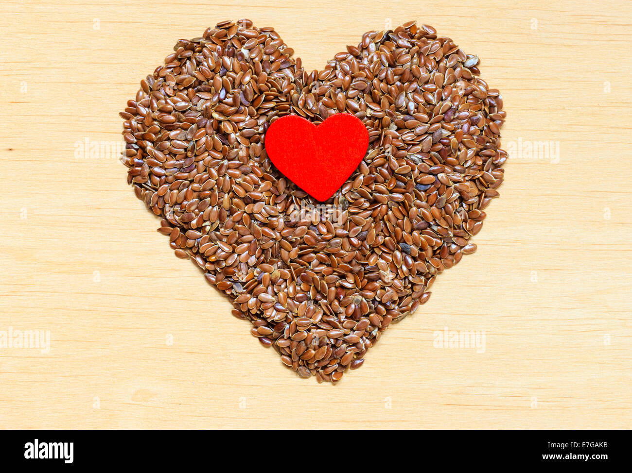 Diet healthcare concept. Raw flax seeds linseed heart shaped on wooden background. Healthy food ...