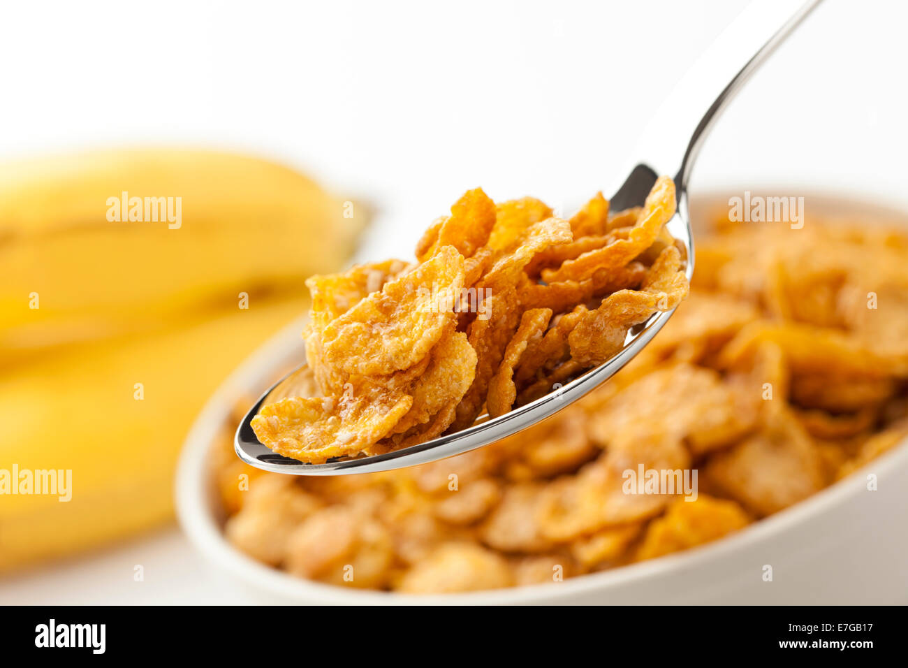 corn flakes on a spoon above bowl, closeup Stock Photo - Alamy