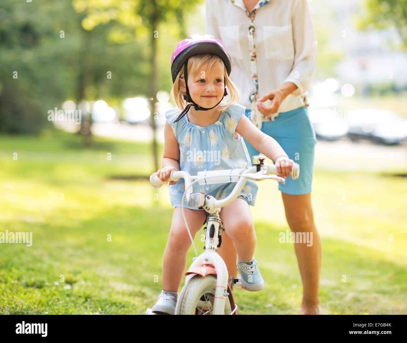 Mother and baby girl riding bicycle outdoors Stock Photo - Alamy