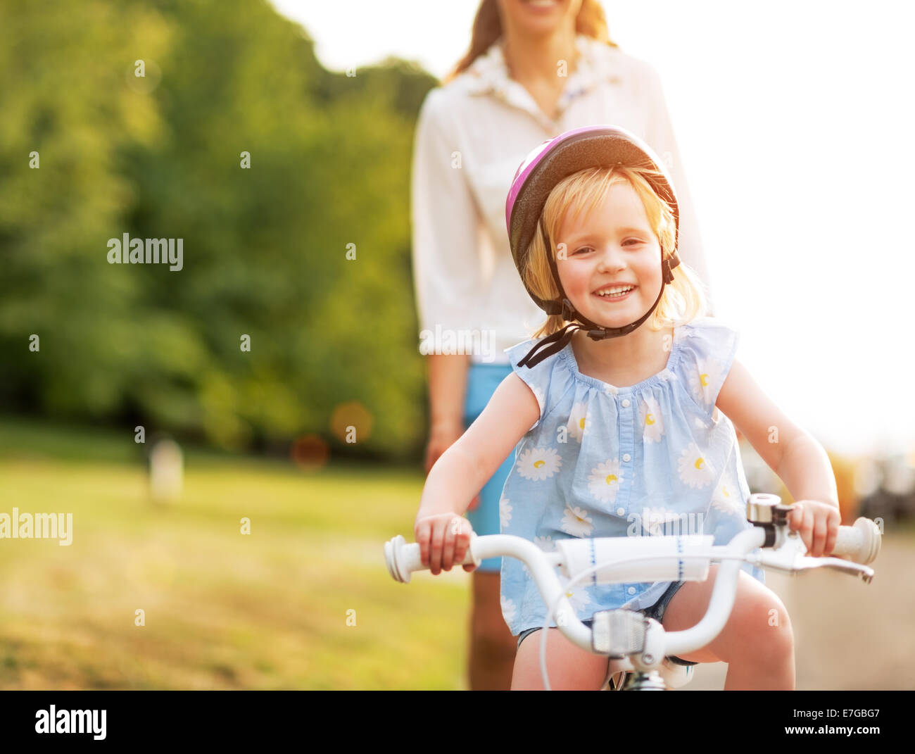 Smiling baby girl riding bicycle Stock Photo - Alamy