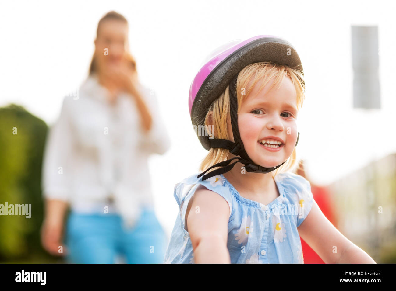 Portrait of smiling baby girl riding bicycle Stock Photo - Alamy