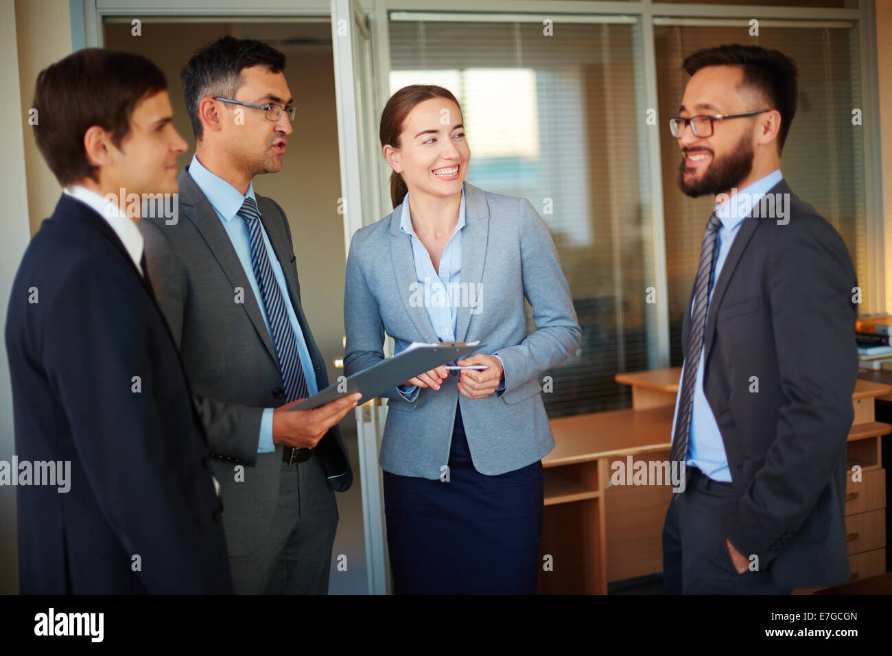 Group of happy colleagues looking at their partner while interacting in ...