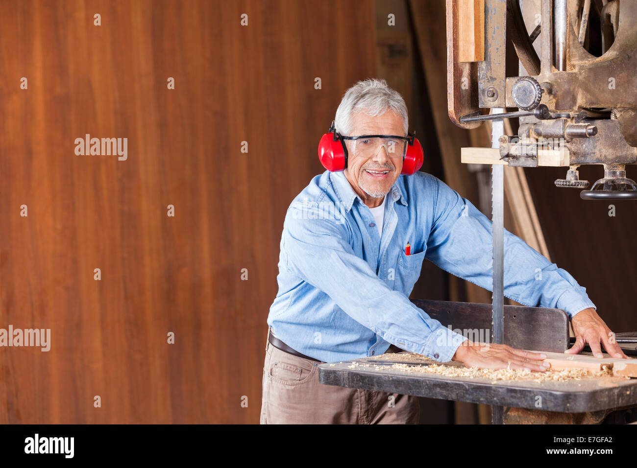 Senior Carpenter Cutting Wood With Bandsaw Stock Photo - Alamy