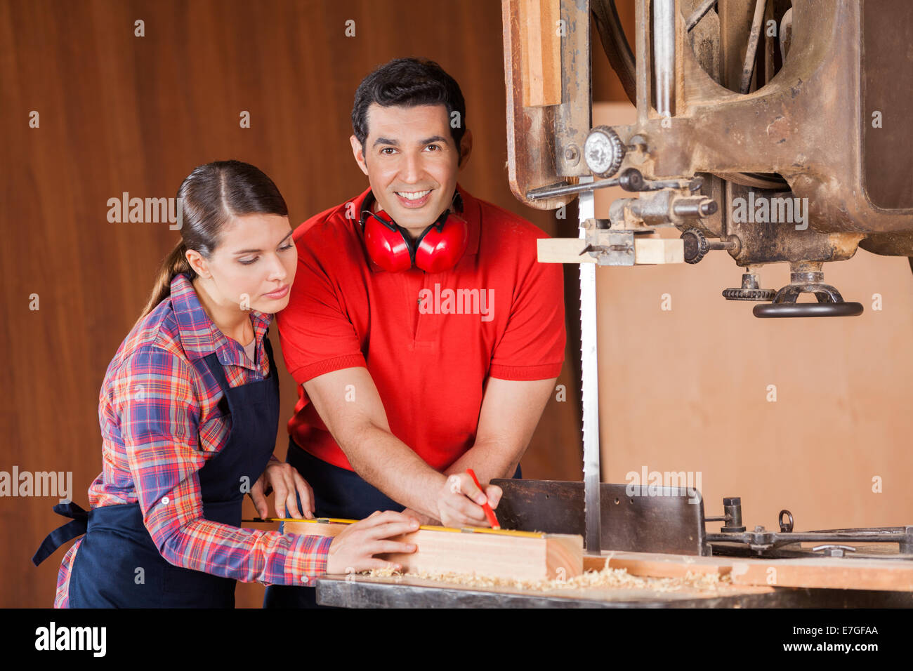 Carpenter Measuring Wood With Coworker In Workshop Stock Photo - Alamy