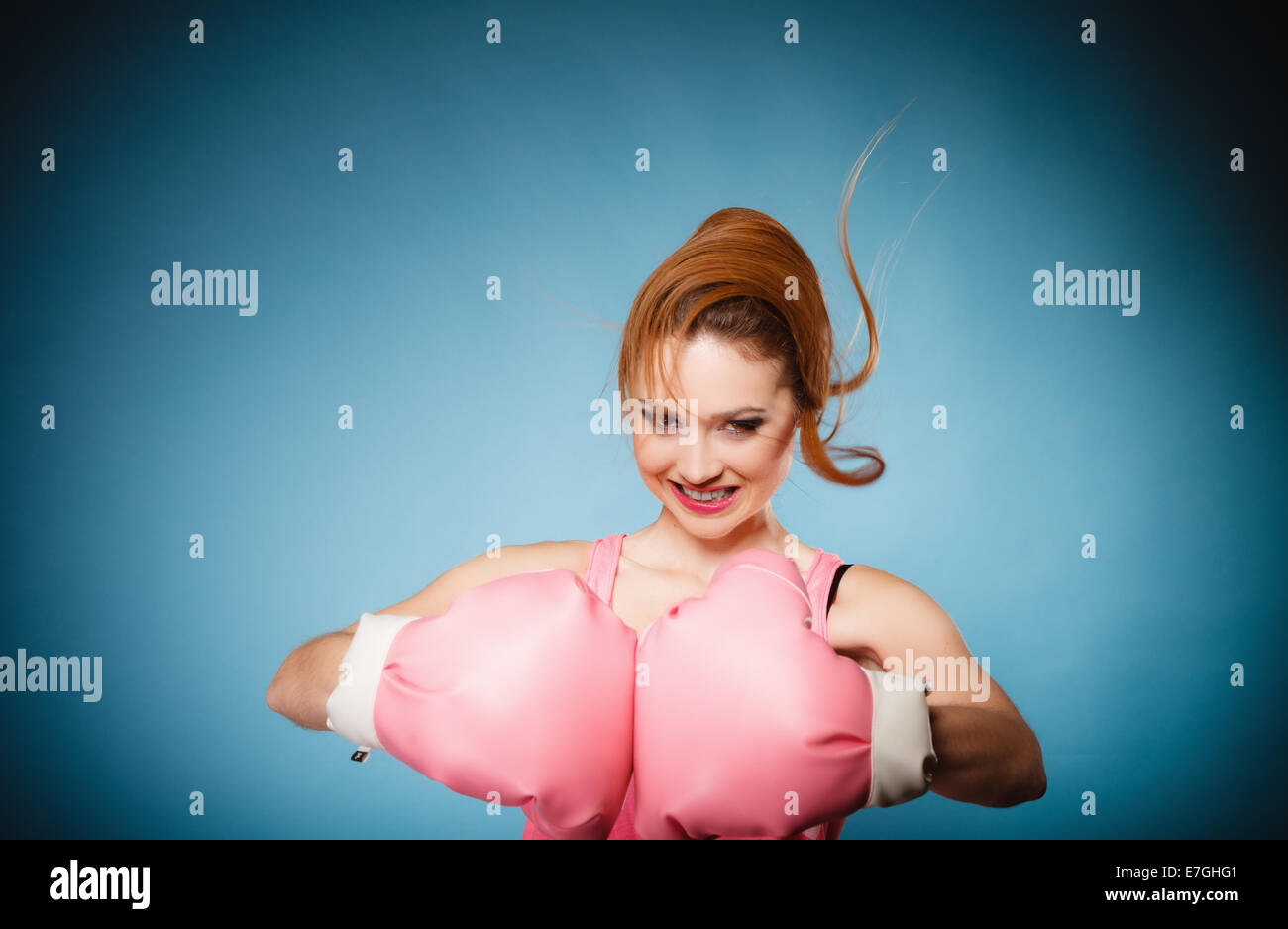 Funny girl female boxer in big fun pink gloves playing sports boxing ...