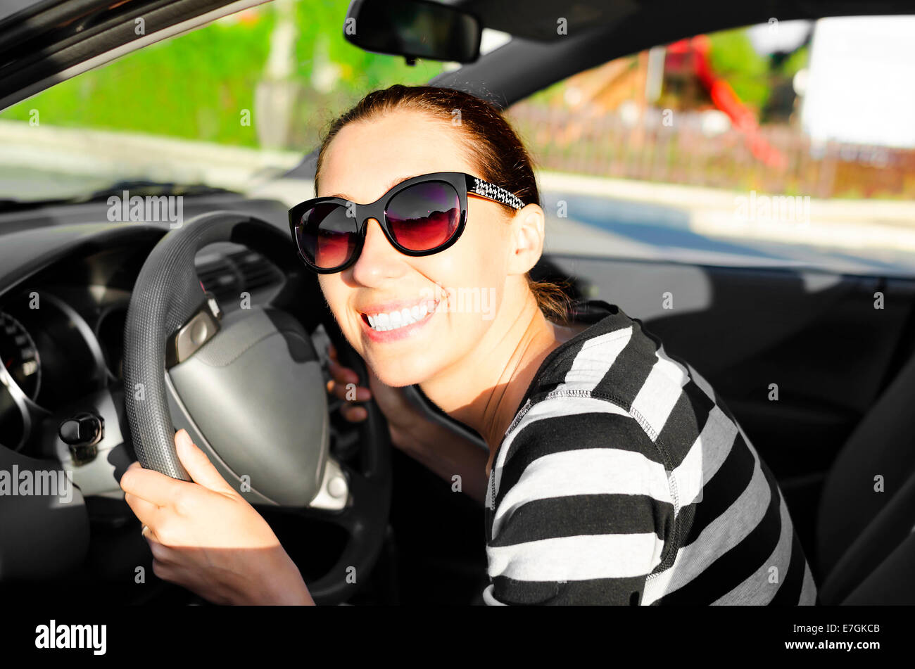 Woman drives a car on the road and smiling Stock Photo - Alamy