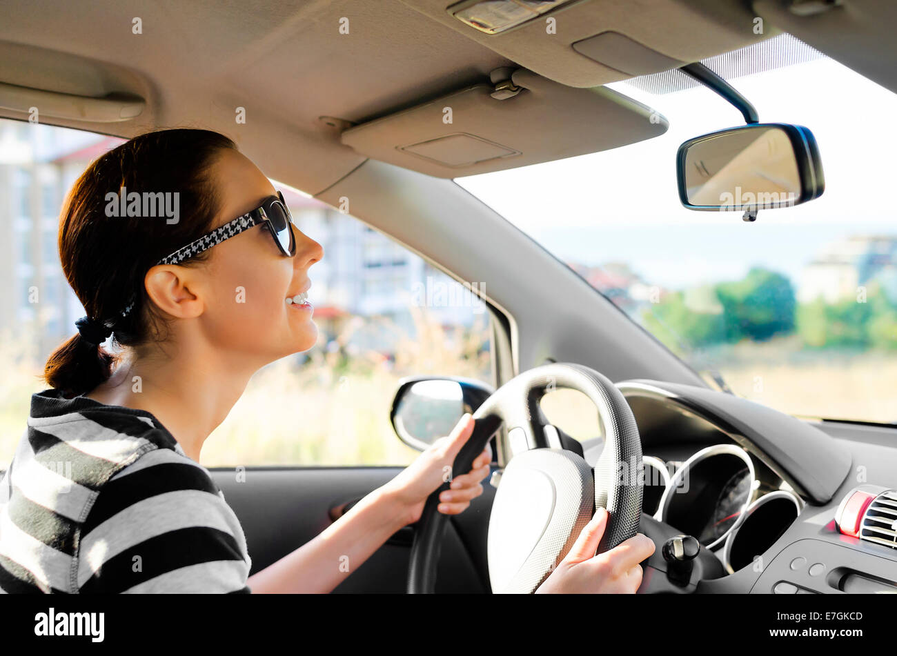 Woman drives a car on the road and smiling Stock Photo - Alamy