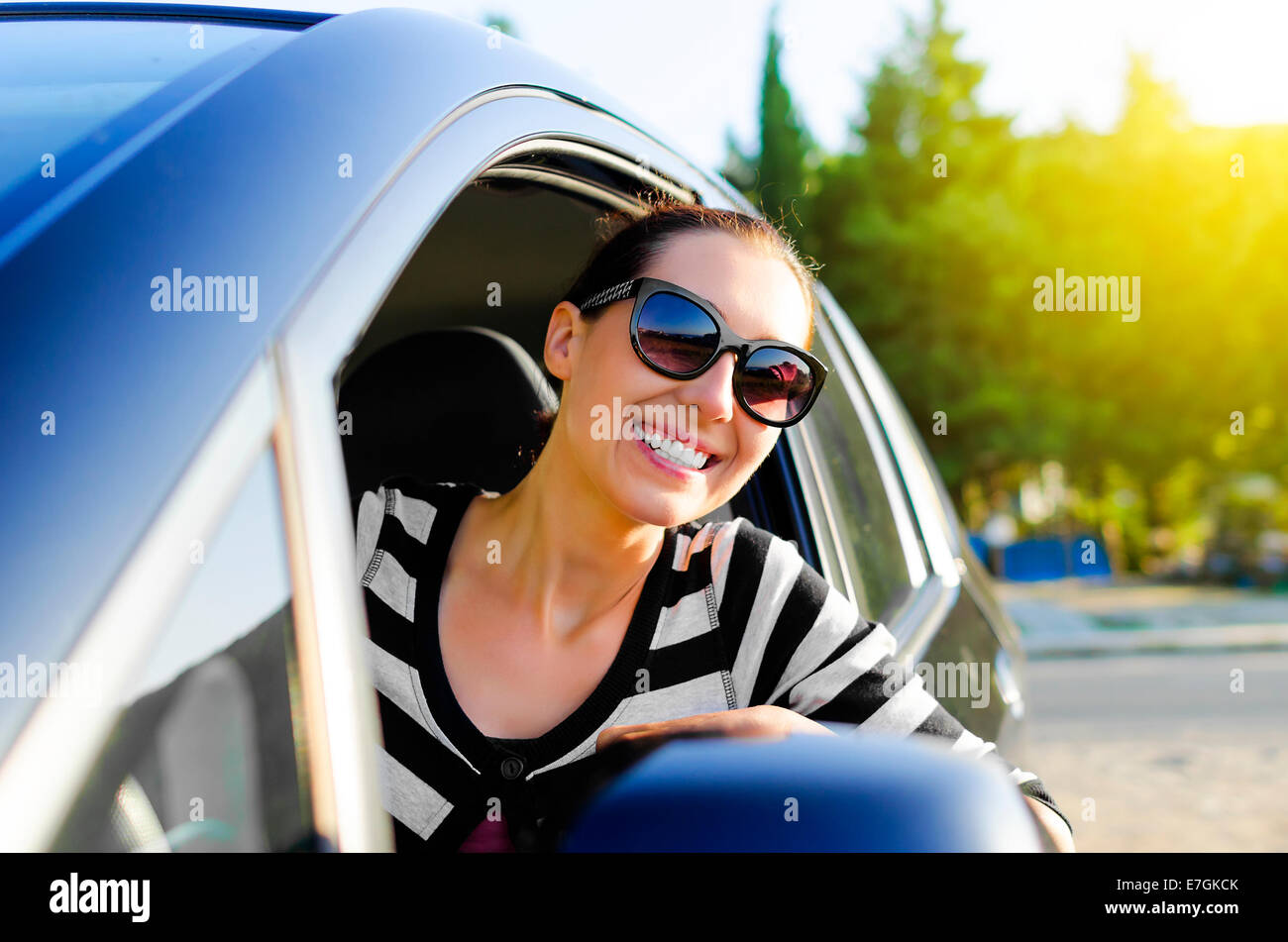 Woman drives a car on the road and smiling Stock Photo - Alamy