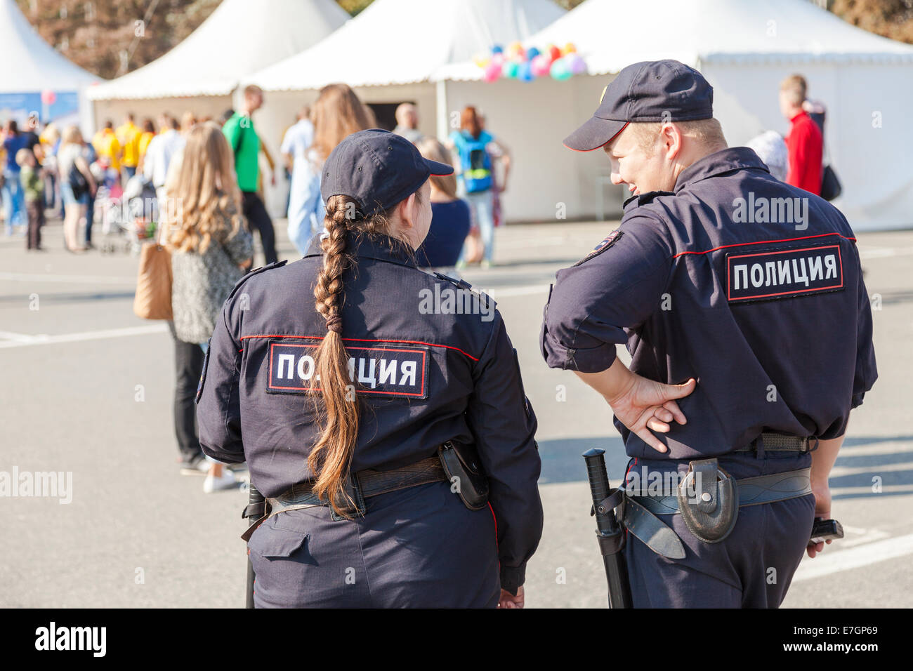 Police patrol in the town square in summer sunny day. Text in russian ...