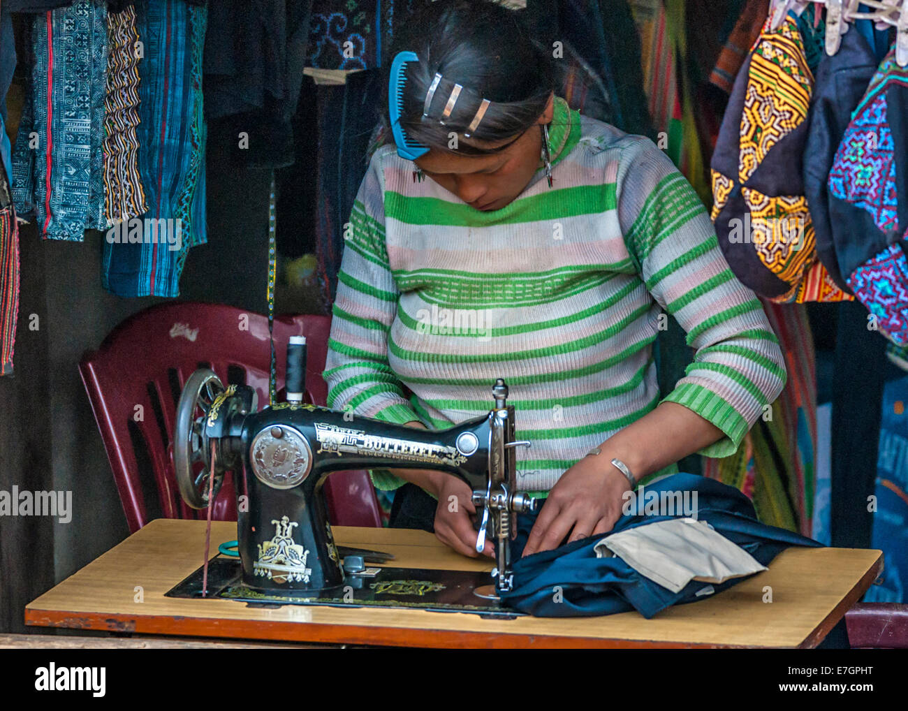 Woman sewing in the window of her shop Stock Photo - Alamy
