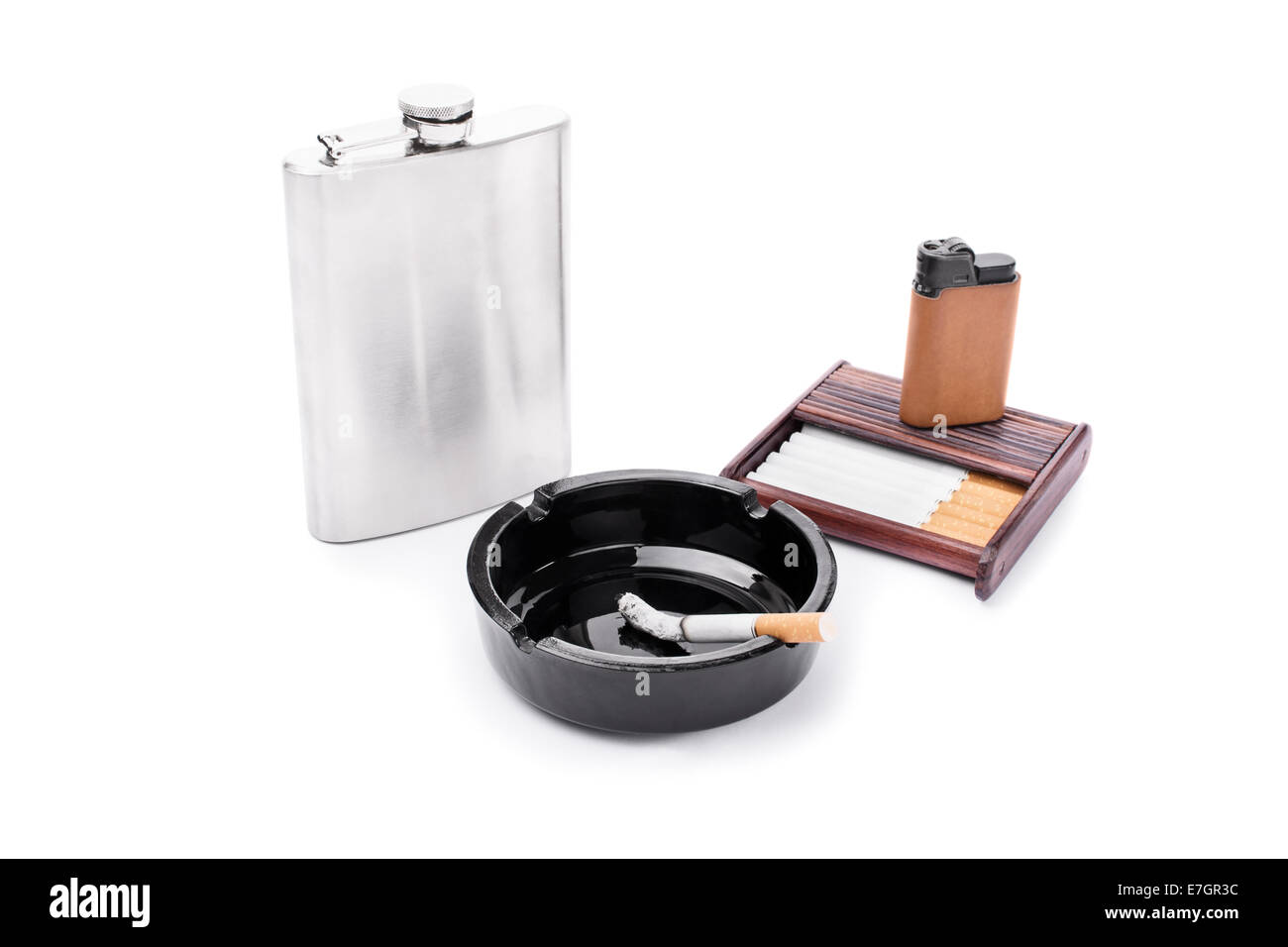 Stainless steel flask, ashtray, some cigarettes, and lighter on a ...