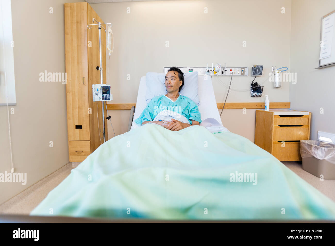 Thoughtful Male Patient Reclining On Hospital Bed Stock Photo - Alamy