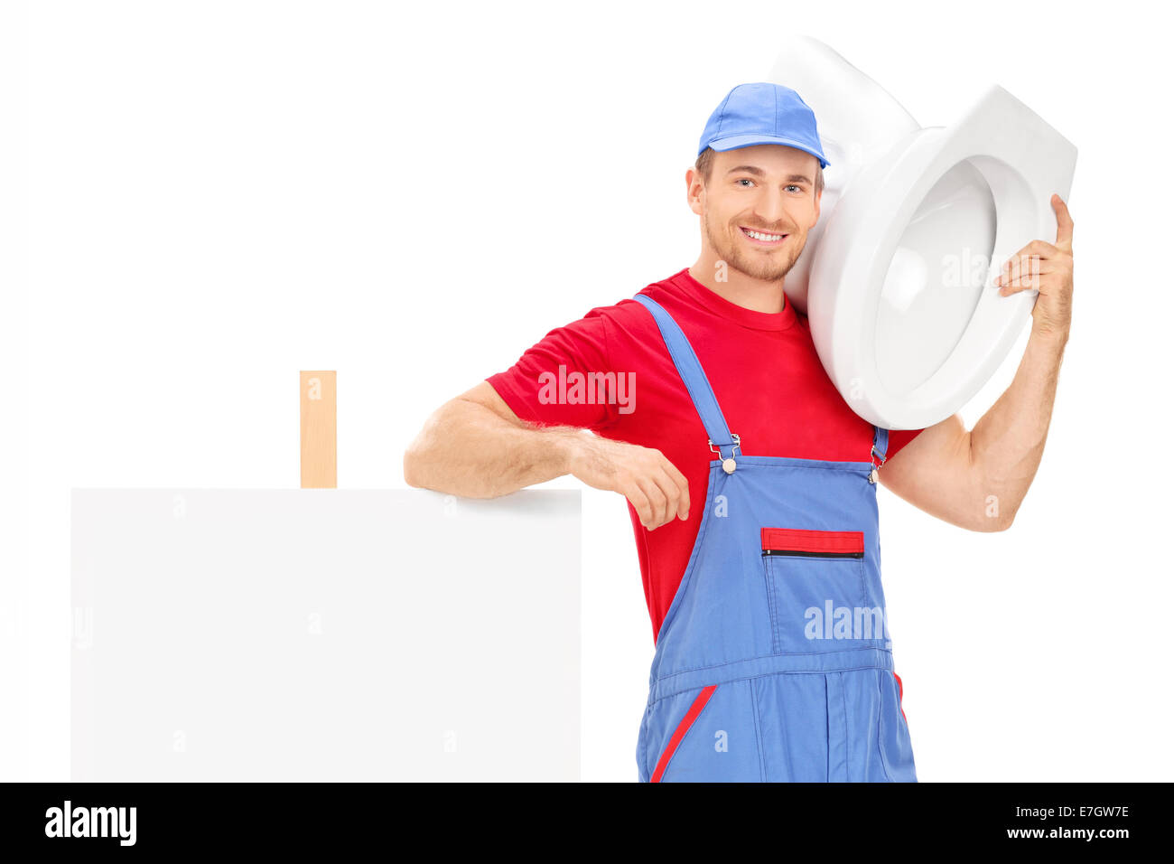 Male plumber standing by a blank signboard isolated on white background ...