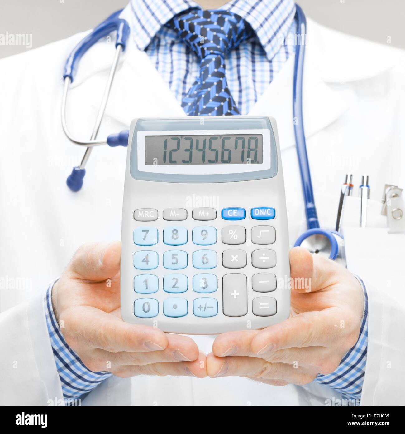 Medical doctor with calculator in his hand - studio shoot - 1 to 1 ...