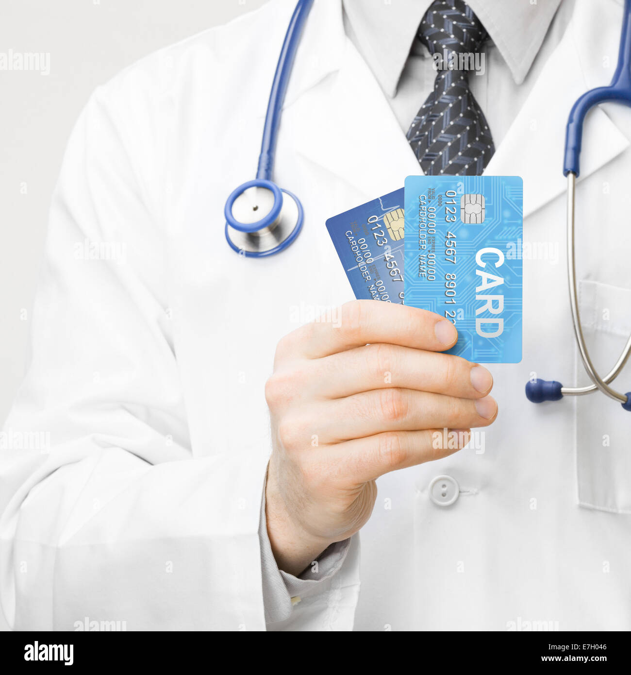 Doctor holding credit cards in his hand - closeup studio shot - 1 to 1 ...