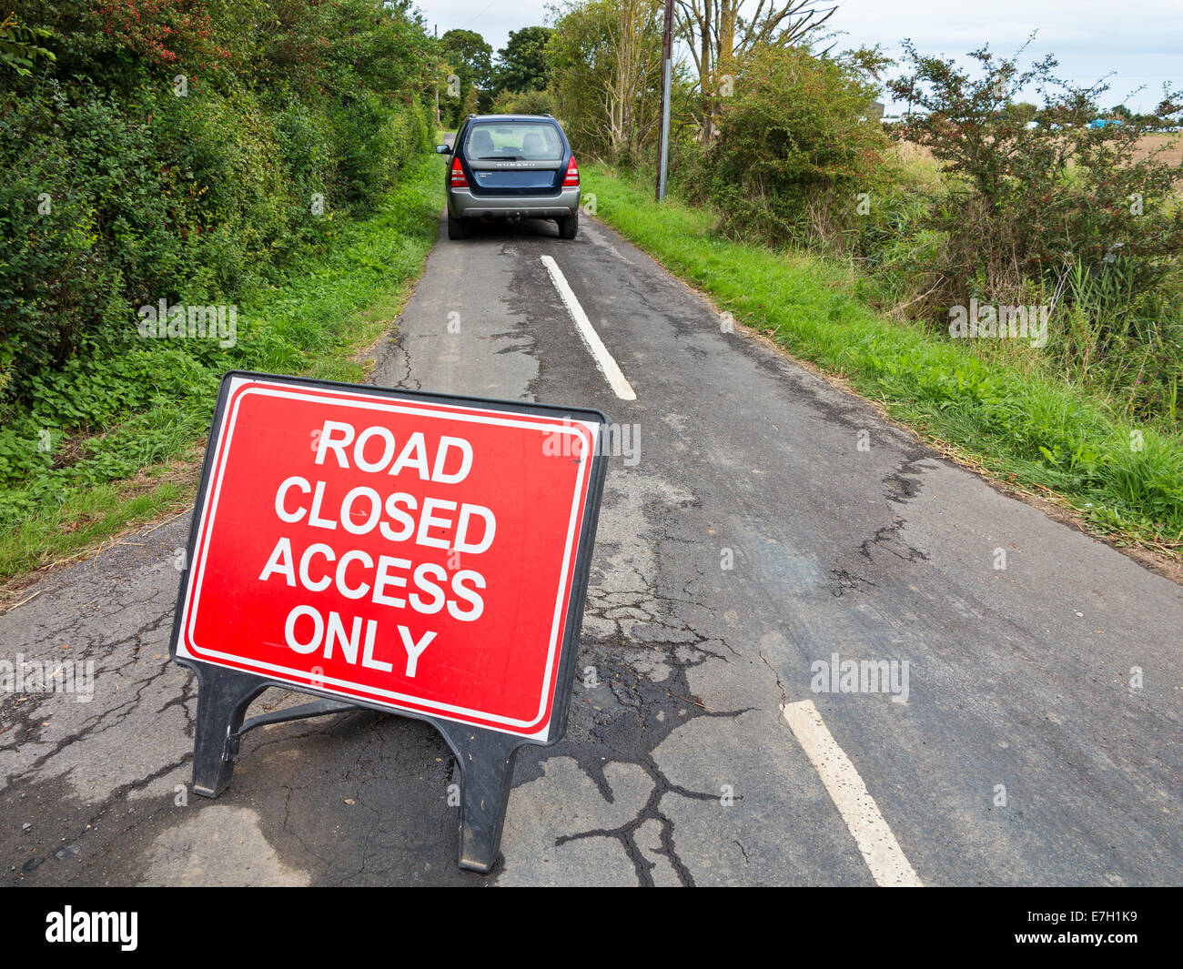 A driver ignores a closed road sign and drives down a road in the ...