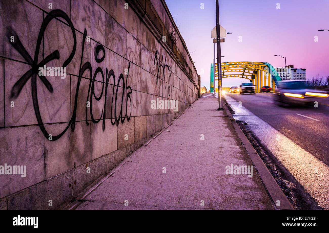Graffiti on a wall and traffic moving over the Howard Street Bridge in ...