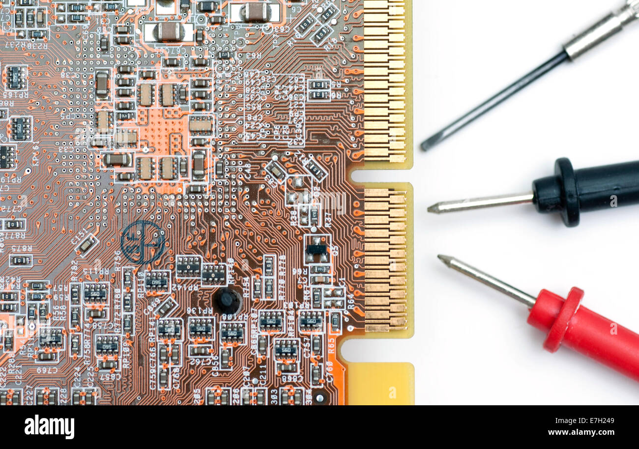 Computer circuit board with multimeter sticks and a mini screw driver ...